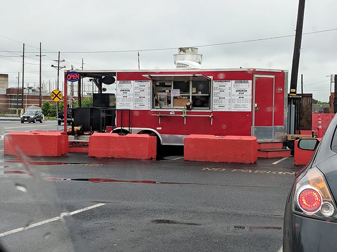 The bright red food truck stands like a culinary lighthouse in the parking lot, beckoning hungry souls with promises of smoky delights.