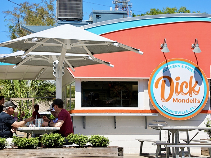 The bright orange and turquoise exterior isn't just eye-catching&mdash;it's a siren call to burger lovers everywhere. Florida sunshine and shade umbrellas complete the perfect dining setup.