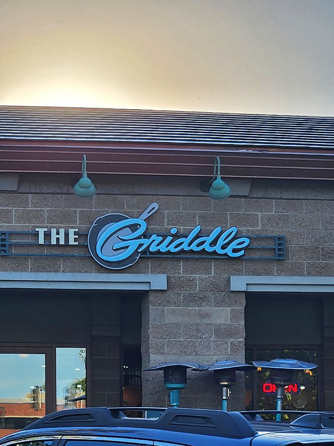 The stylish exterior of The Griddle beckons with its warm stone facade and signature blue lamps&mdash;breakfast paradise hiding in plain sight.