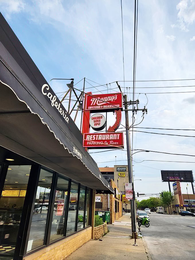 Manny's iconic red sign stands like a culinary lighthouse against Chicago's skyline, promising delicious refuge from the busy world outside.