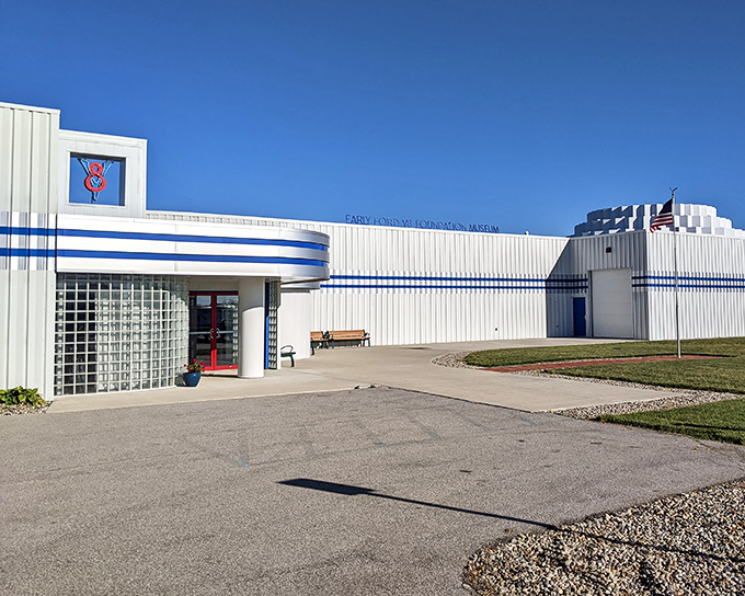 A gleaming 1936 Ford sedan poses like a silver screen starlet against the museum's distinctive white architecture. Automotive time travel at its finest.