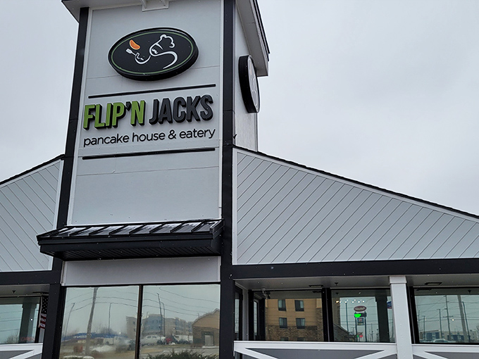 The distinctive peaked roof and farmhouse-style railing of Flip'N Jacks stands like a breakfast beacon in Ames, promising pancake paradise within.