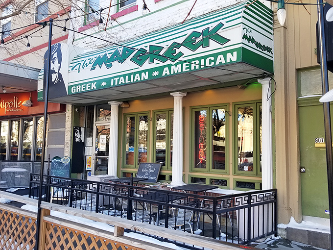 The Mad Greek's inviting storefront beckons with classic white columns and cheerful patio umbrellas&mdash;Massachusetts Street's little slice of Athens awaits your discovery.