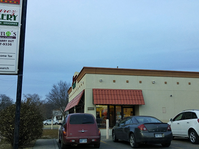 The tan building with striking red awnings beckons like a lighthouse for carb enthusiasts. One glance at that "OPEN" sign and resistance becomes futile.