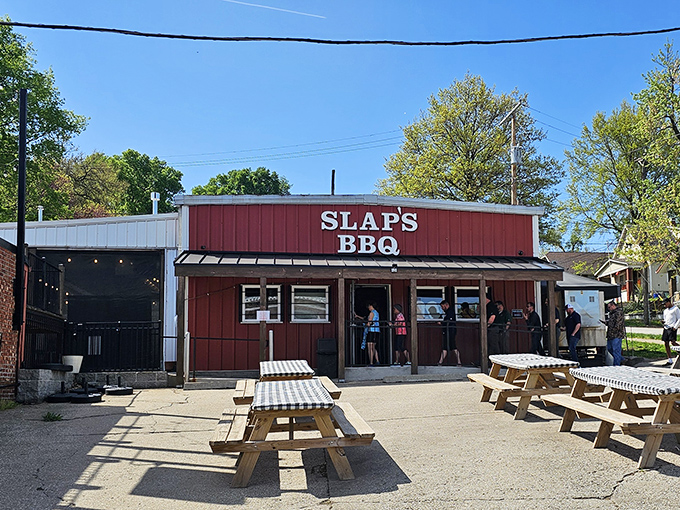 The red-sided barbecue temple of Slap's stands ready for pilgrims, picnic tables waiting like front-row seats to the greatest meat show on earth.