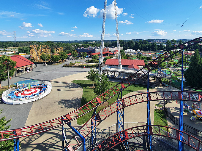 A bird's-eye view of Adventure Park USA reveals its colorful kingdom of fun, where roller coaster tracks weave between classic carnival rides like a steel and concrete quilt of joy.