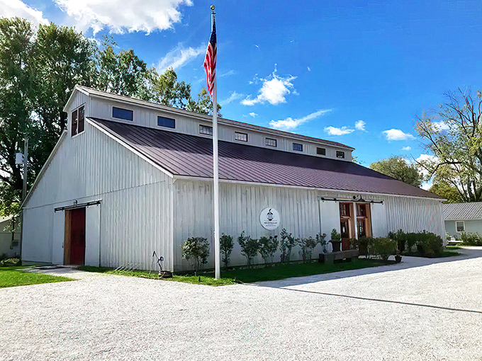 The Classic Motor Museum's weathered barn exterior houses automotive treasures inside, while a cherry-red Alfa Romeo Spider teases what awaits curious visitors.