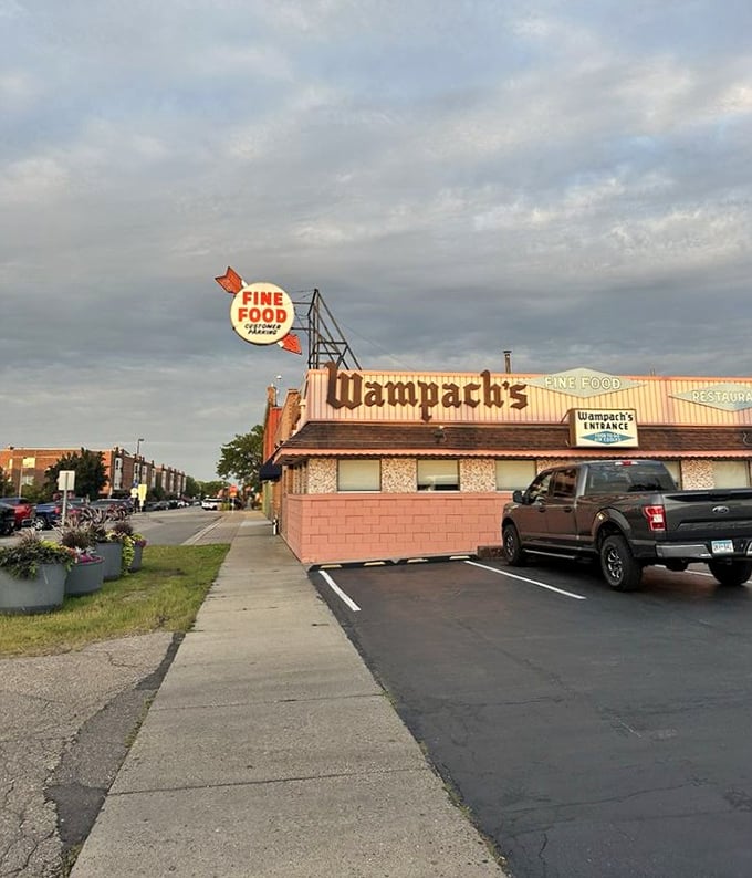 The pink brick facade of Wampach's stands like a time capsule, promising "FINE FOOD" with the confidence of someone who's been keeping that promise for decades.