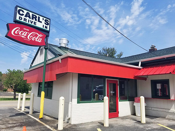 The iconic red and white exterior of Carl's Drive-In stands as a time capsule on Manchester Road, complete with its vintage Coca-Cola sign that's been guiding hungry travelers since the 1950s.