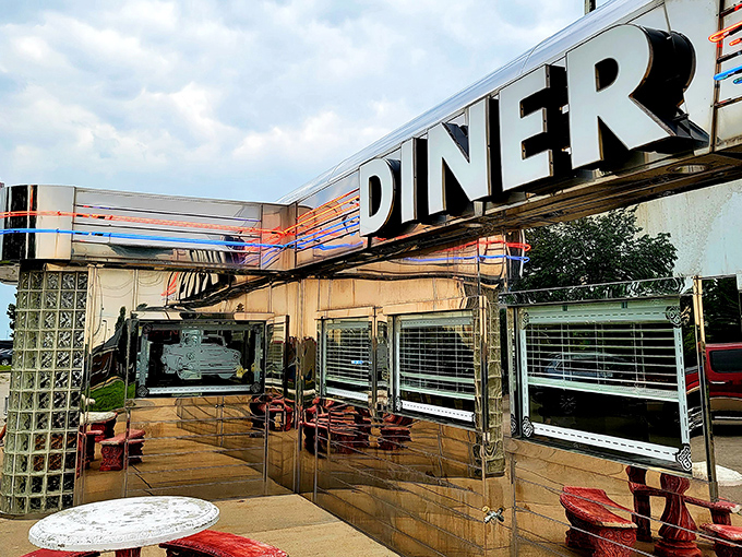 That iconic sign beckons like a chrome-clad siren song from the roadside, promising a journey back to when highways meant adventure, not just commutes.