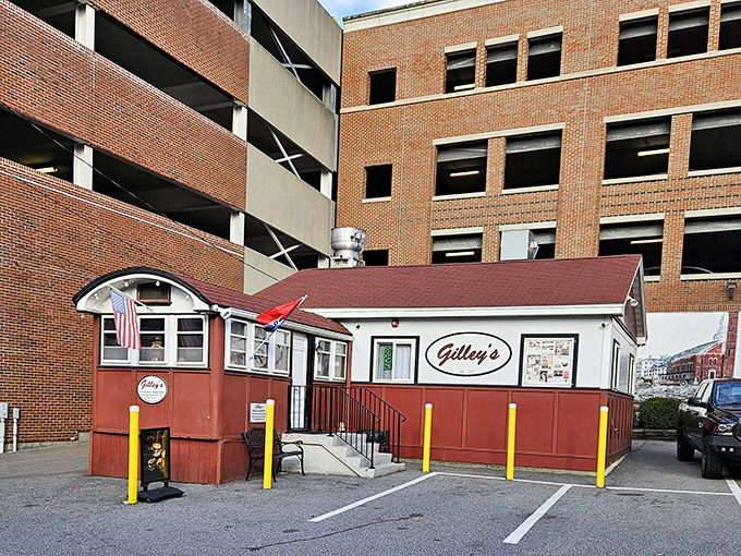 A humble red and white diner nestled against a parking garage&mdash;proof that culinary treasures often hide in plain sight.