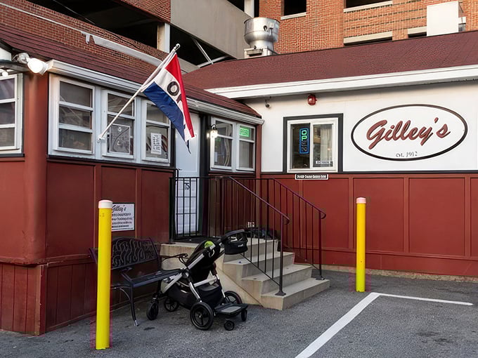 A humble red and white diner nestled against a parking garage—proof that culinary treasures often hide in plain sight.