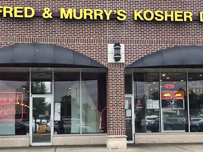 The Promised Land of pastrami sits quietly in a strip mall, its yellow sign a beacon to hungry souls seeking deli salvation.