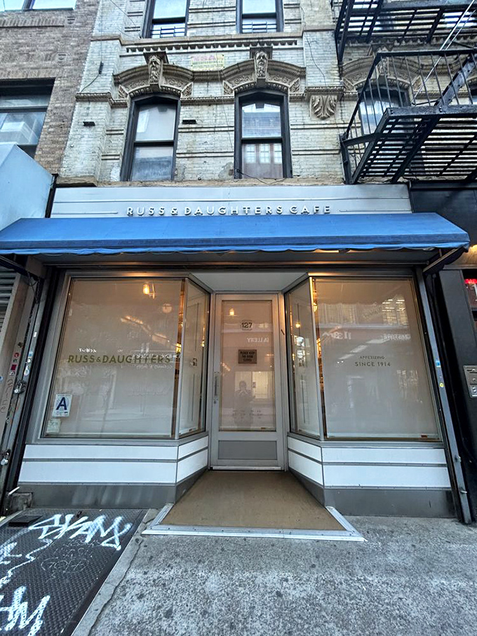The iconic blue awning of Russ & Daughters Cafe stands out like a culinary lighthouse, guiding hungry souls to this Lower East Side institution. 