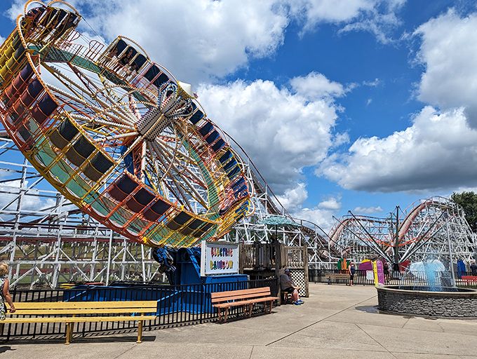 The classic Scrambler ride spins against a backdrop of wooden coaster tracks &ndash; a perfect snapshot of old-school amusement park magic that never goes out of style.
