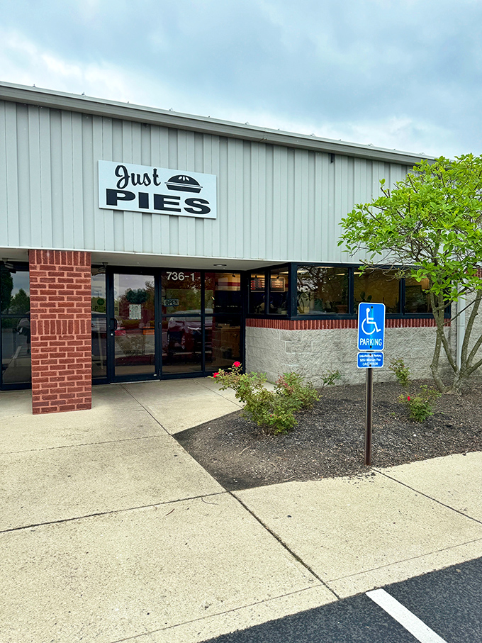 The unassuming exterior of Just Pies belies the magic happening inside. Like finding a treasure chest disguised as a storage shed.