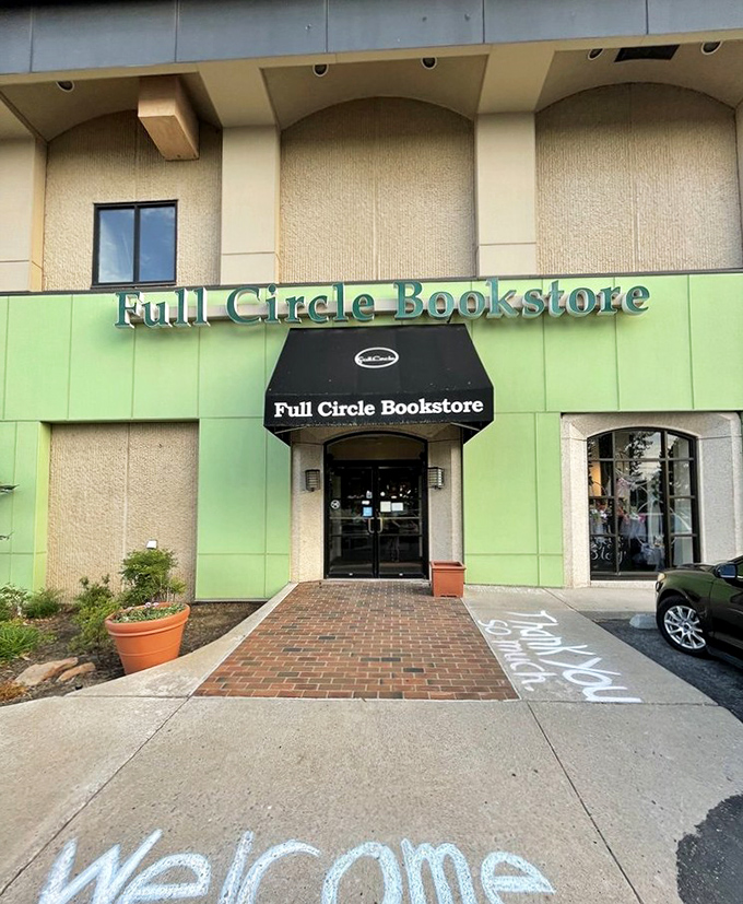 The distinctive green facade of Full Circle Bookstore welcomes bibliophiles with a chalk-written "Welcome" that feels like a literary hug.