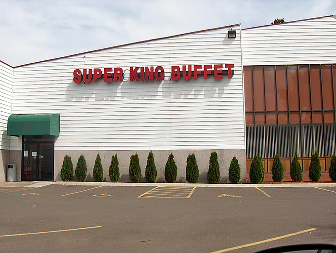 The unassuming exterior of Super King Buffet stands like a culinary fortress, promising treasures within that the modest fa&ccedil;ade cleverly conceals from passing traffic. 