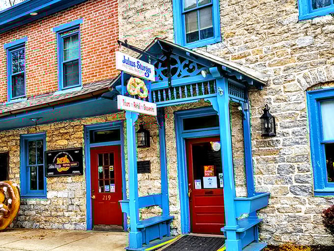 A stone and brick facade with bright blue trim and welcoming red doors – Julius Sturgis stands as a beacon of pretzel perfection in charming Lititz.