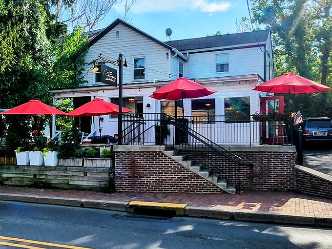 The white clapboard charm of The Burgerly beckons from the street, those vibrant red umbrellas promising shade for your burger-induced bliss.