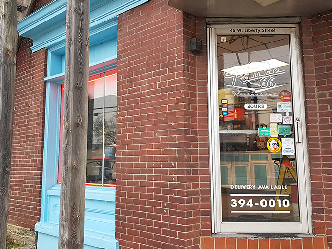 The unassuming brick entrance with its vibrant blue trim promises more than meets the eye&mdash;a perfect roadside discovery hiding in plain sight on Liberty Street.