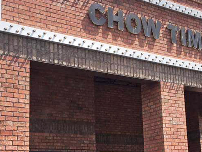 The brick facade of Chow Time beckons like a siren song to hungry travelers. No fancy frills needed when what's inside matters most.