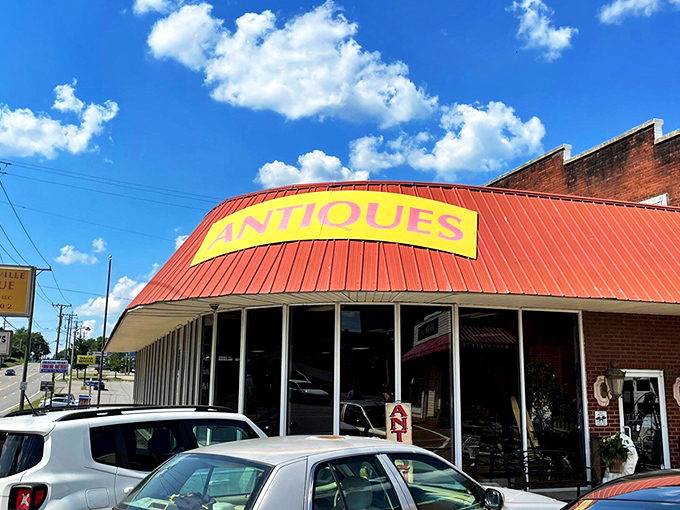 Peek down a corridor of curiosities where treasure hunters navigate a sea of vintage wonders under the watchful eye of a blue bicycle suspended in mid-flight.