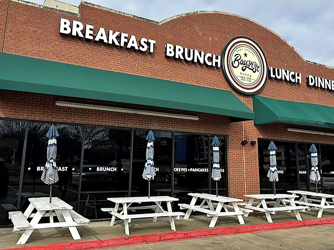 The brick facade with teal awnings isn't just inviting&mdash;it's practically shouting "Come get breakfast!" Those white picnic tables are waiting for your morning revelation.