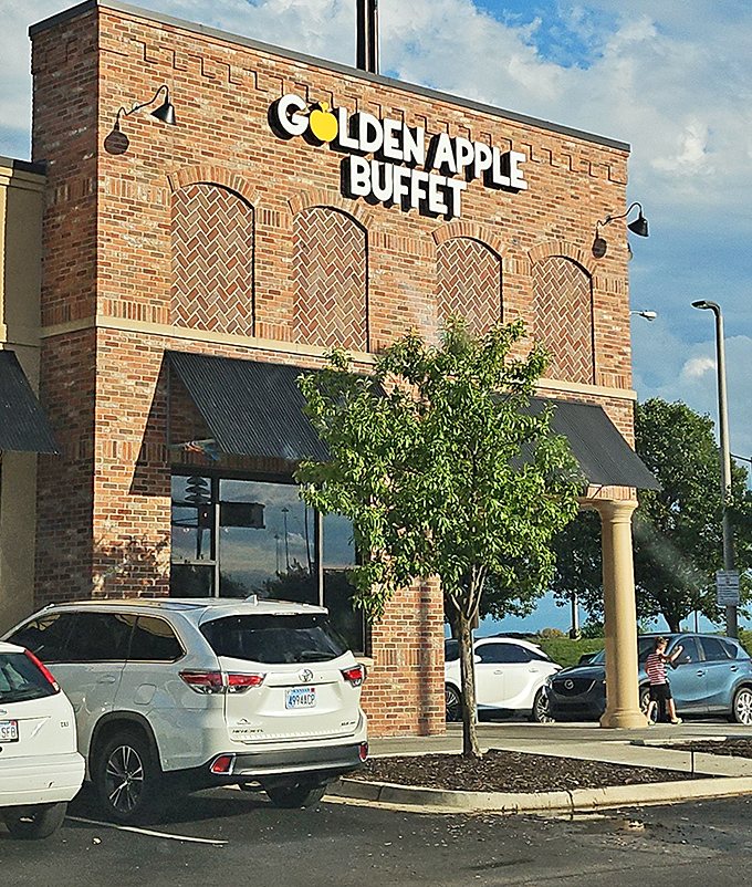 The brick facade of Golden Apple Buffet stands like a temple to abundance, promising culinary adventures behind those metal-awninged windows.