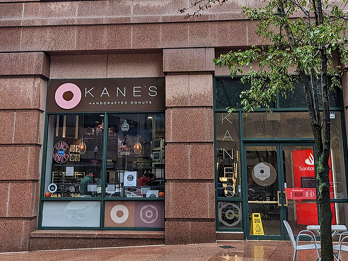 Kane's iconic storefront in Boston's Financial District beckons like a pink-glazed lighthouse to donut lovers navigating the urban sea of steel and stone.