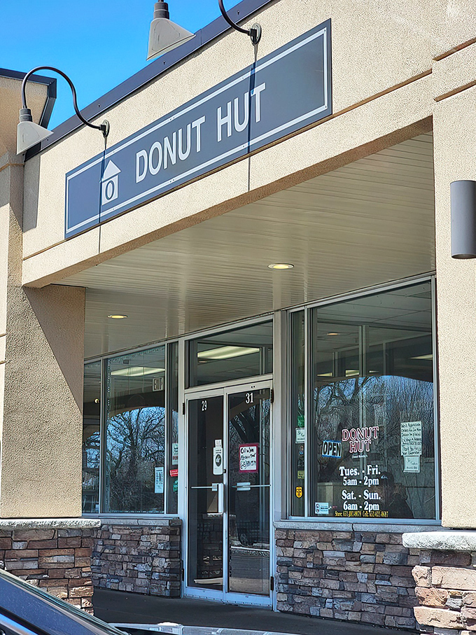 The humble storefront belies the sugary treasures within. Donut Hut's glowing "OPEN" sign serves as a beacon for pastry pilgrims across the Twin Cities.