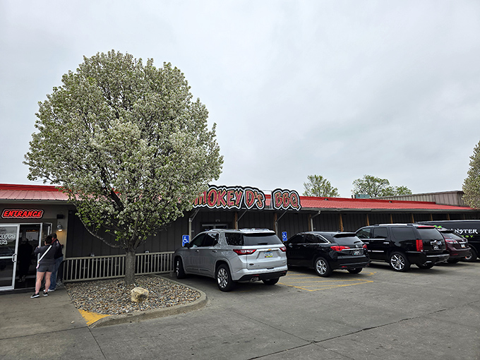The unassuming exterior of Smokey D's BBQ, where the parking lot's always full and that heavenly smoke aroma greets you before the door does.