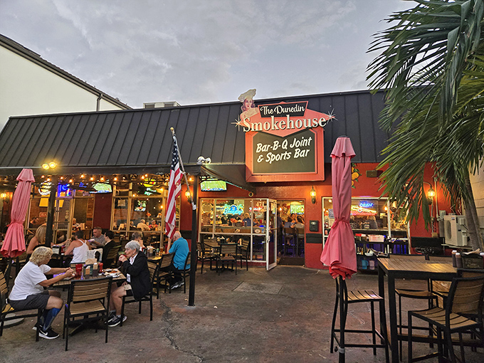 The Dunedin Smokehouse's vibrant exterior beckons like a barbecue siren, with its inviting patio where locals gather to worship at the altar of smoked meats.