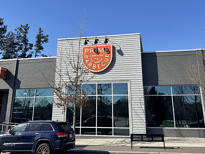 Modern meets mouthwatering at Prime Barbecue's sleek Knightdale exterior. The orange shield logo beckons like a barbecue bat-signal to hungry heroes everywhere.