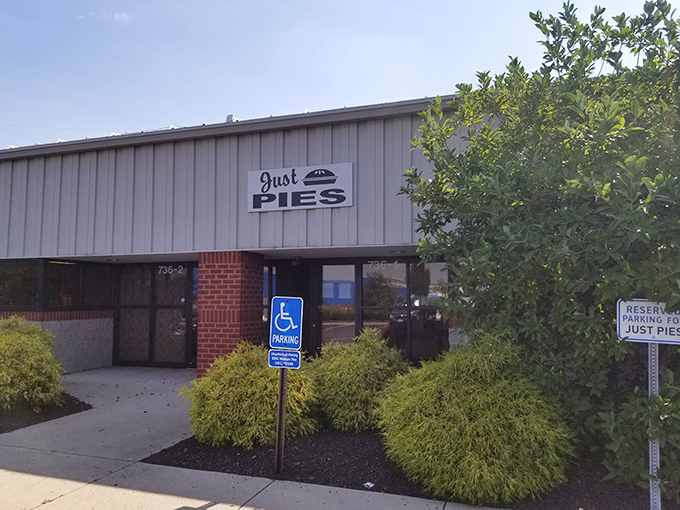 The unassuming exterior of Just Pies belies the magic happening inside. Like finding a treasure chest disguised as a storage shed.
