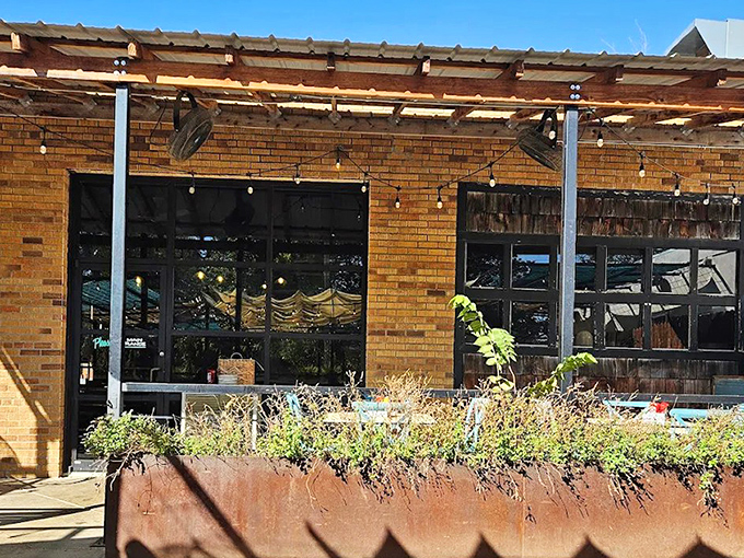 The Press's rustic brick exterior with string lights and weathered planters creates that perfect "I've discovered something special" vibe in Oklahoma City's Midtown.