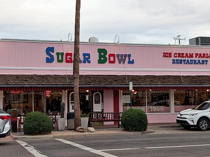 The iconic pink facade of Sugar Bowl stands as a sweet beacon in Old Town Scottsdale, its colorful lettering promising frozen happiness inside.
