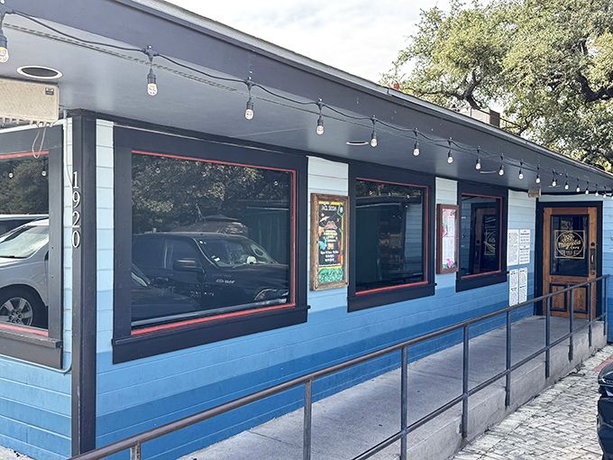 The iconic blue exterior of Magnolia Cafe stands as an Austin landmark, its welcoming porch and signature sign beckoning hungry pilgrims at all hours.