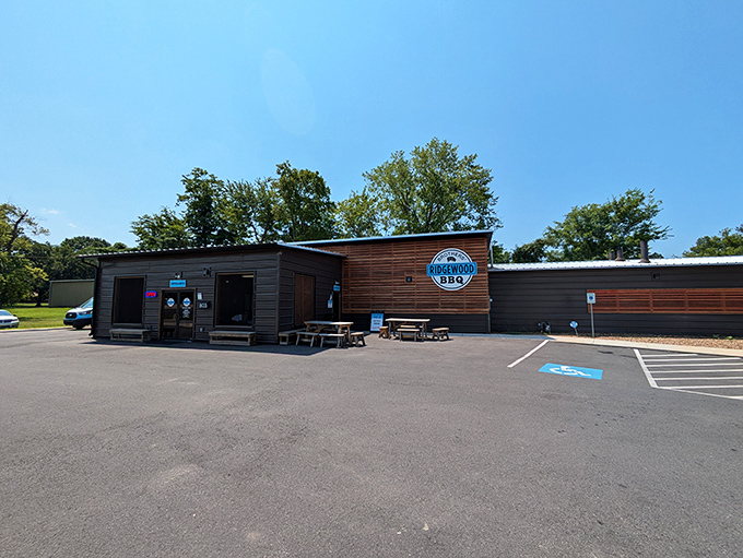 The modern wooden facade of Ridgewood Brothers BBQ stands like a beacon of hope for hungry travelers. Simple picnic tables outside hint at the no-frills focus on what matters most: the meat.