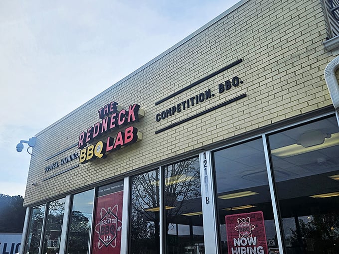 The white brick exterior with bold red and yellow signage announces what you're in for: serious barbecue wrapped in a playful scientific package.