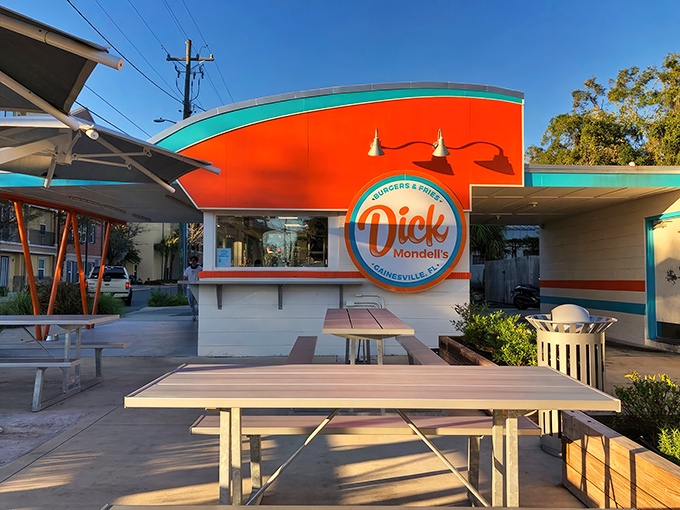 The bright orange and turquoise exterior isn't just eye-catching&mdash;it's a siren call to burger lovers everywhere. Florida sunshine and shade umbrellas complete the perfect dining setup.