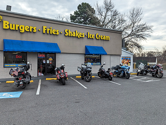 The humble roadside palace where burger dreams come true. Blue awnings and bright yellow signage beckon hungry travelers like a culinary lighthouse.