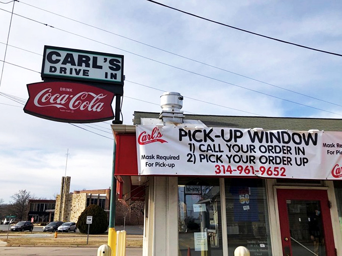 The iconic red and white exterior of Carl's Drive-In stands as a time capsule on Manchester Road, complete with its vintage Coca-Cola sign that's been guiding hungry travelers since the 1950s.