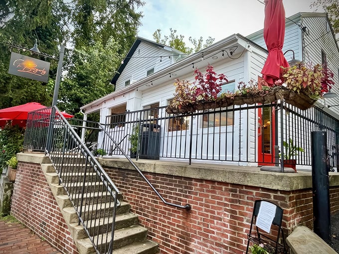 The white clapboard charm of The Burgerly beckons from the street, those vibrant red umbrellas promising shade for your burger-induced bliss.