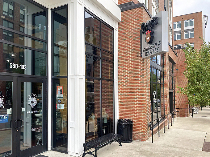 The brick exterior of Dame's Chicken & Waffles stands like a beacon of comfort food in downtown Durham, promising culinary adventures worth every calorie.
