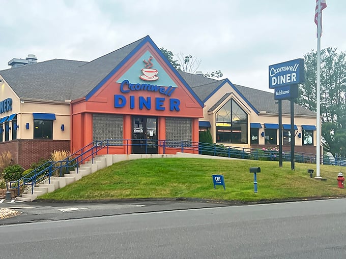 The Cromwell Diner's distinctive blue and orange exterior welcomes hungry travelers like a lighthouse beacon for breakfast enthusiasts navigating the sea of morning hunger.