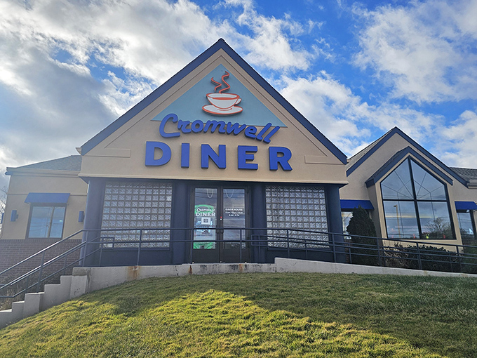 The Cromwell Diner's distinctive blue and orange exterior welcomes hungry travelers like a lighthouse beacon for breakfast enthusiasts navigating the sea of morning hunger. 