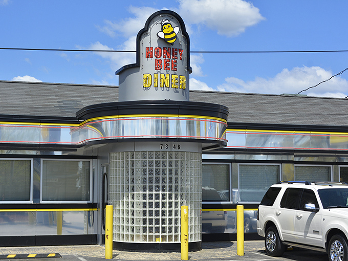 The cheerful cartoon bee sign beckons hungry travelers like a lighthouse for the famished. Even on rainy days, this Glen Burnie landmark promises comfort inside.