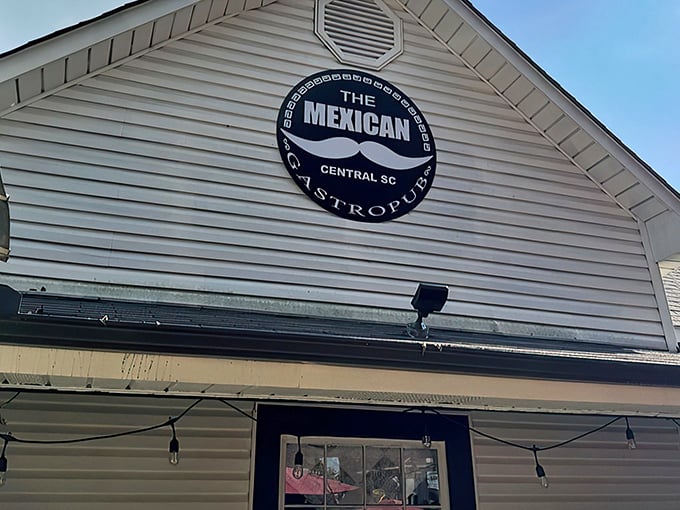 That iconic mustache sign against white clapboard siding says it all: unpretentious exterior, extraordinary flavors waiting inside.