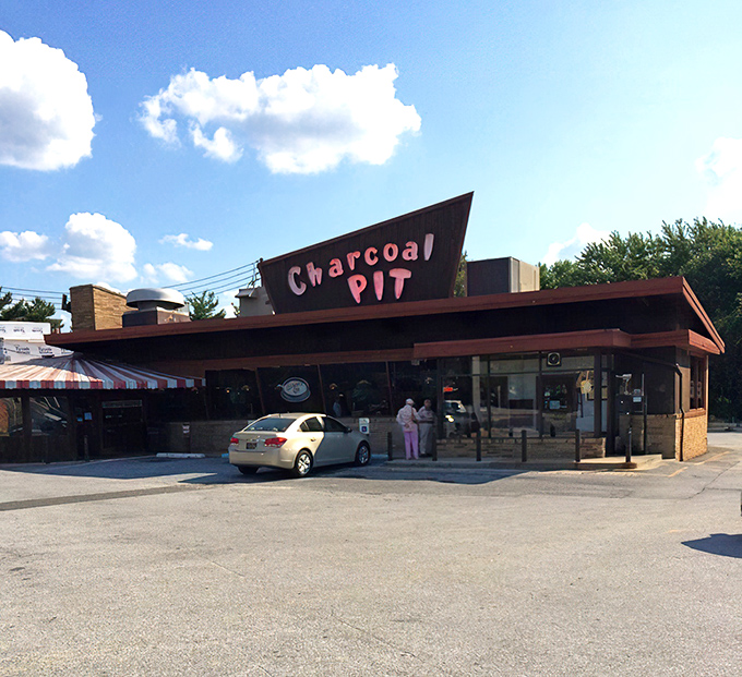 The iconic A-frame roof of Charcoal Pit stands like a mid-century beacon on Concord Pike, promising burger bliss to all who enter.